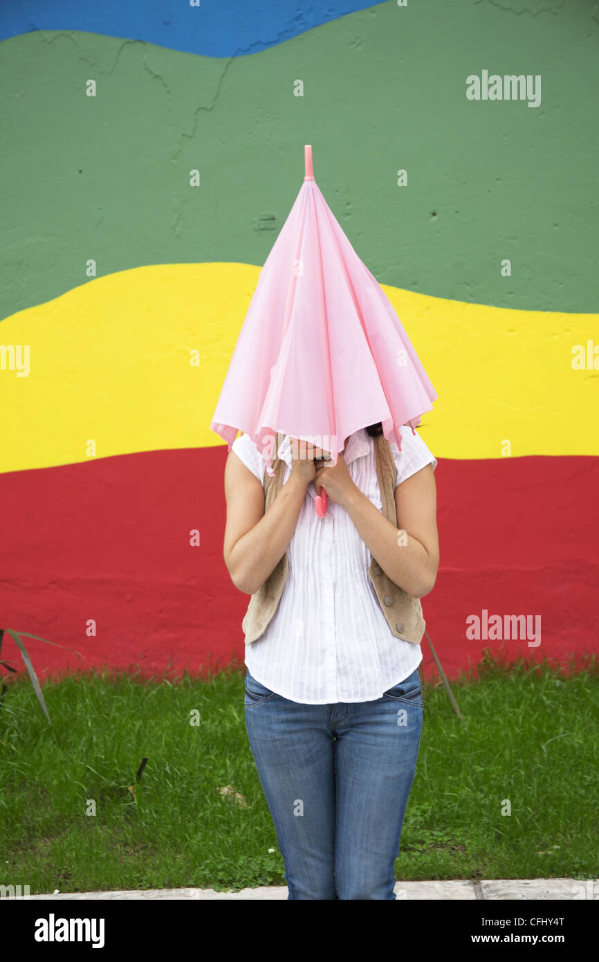 Young woman hiding in umbrella Stock Photo - Alamy