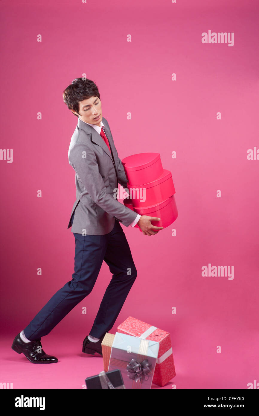A man with the gift boxes dropping from his hands Stock Photo - Alamy