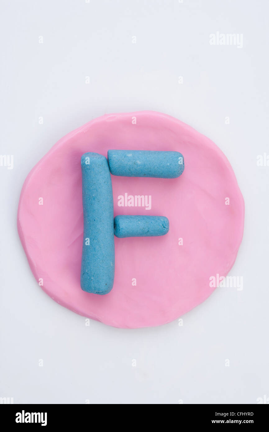 The alphabet F shaped blue clay on the pink circle clay Stock Photo - Alamy
