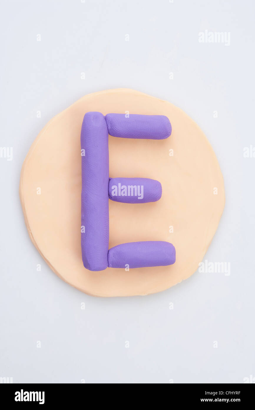The alphabet E shaped purple clay on the orange circle clay Stock Photo ...
