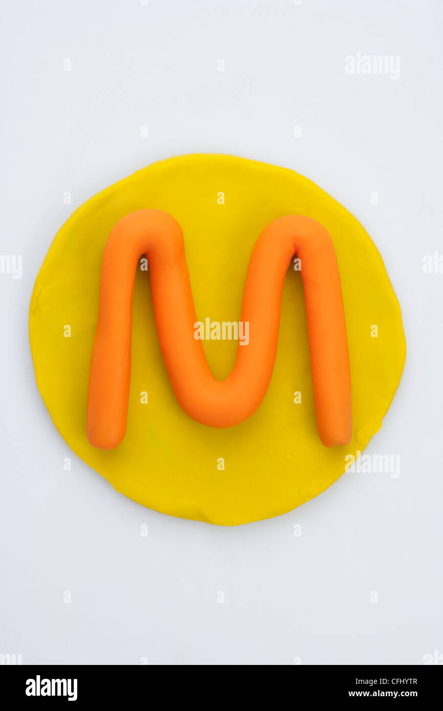 The alphabet M shaped orange clay on the yellow circle clay Stock Photo ...