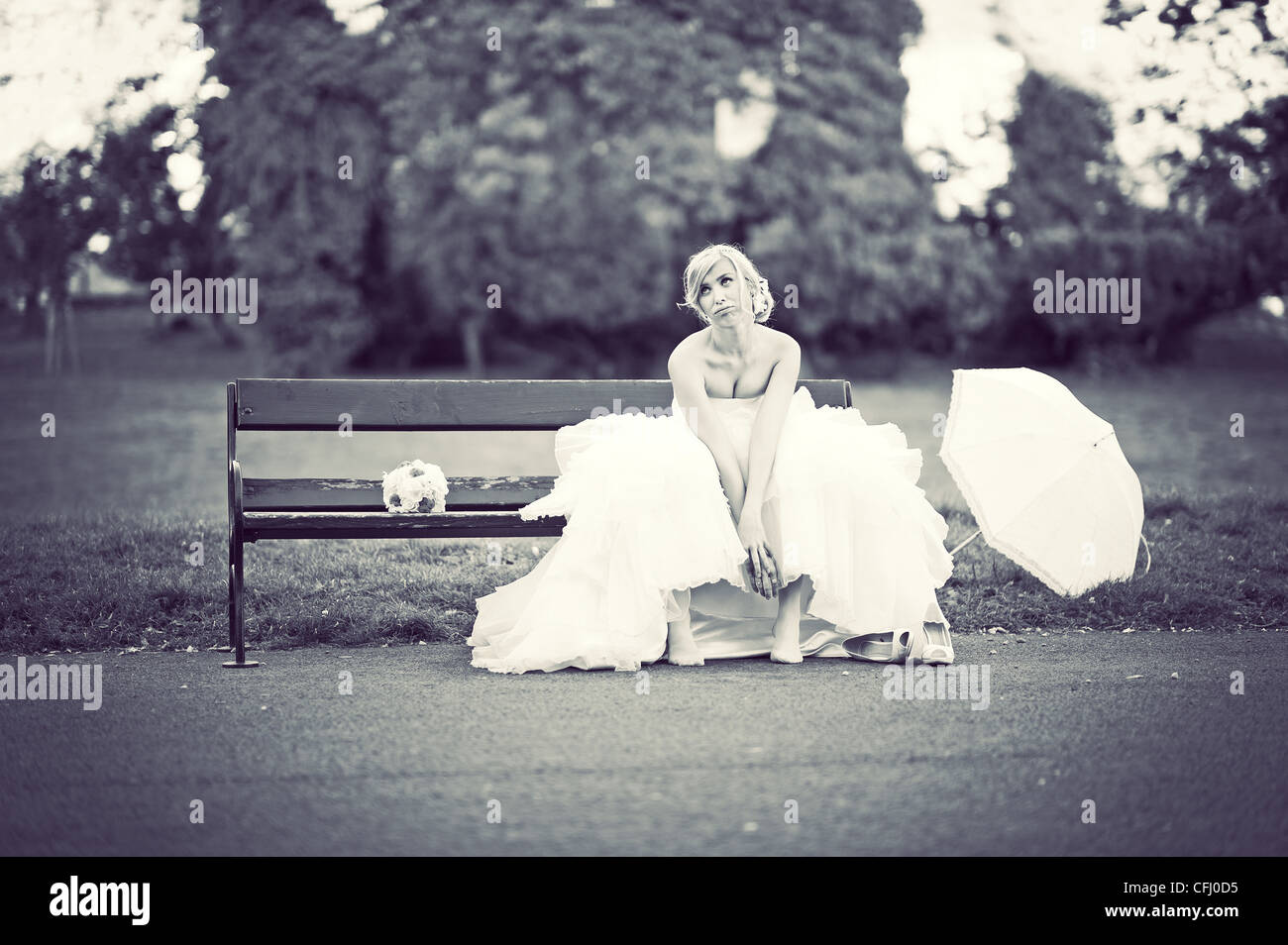 Bored bride sitting on bench waiting for husband Stock Photo - Alamy