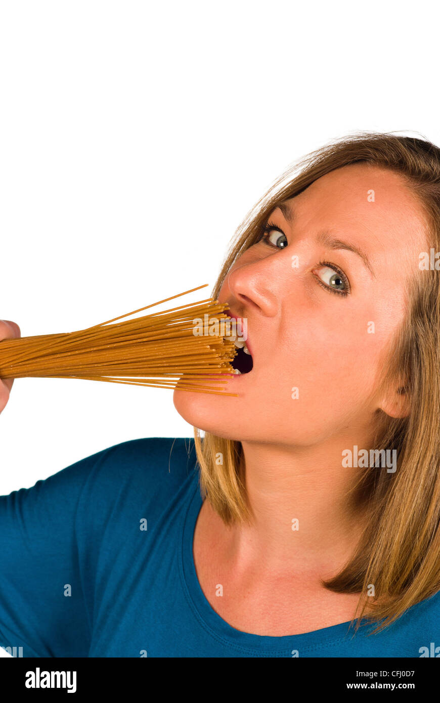 Woman biting into uncooked whole wheat pasta Stock Photo - Alamy