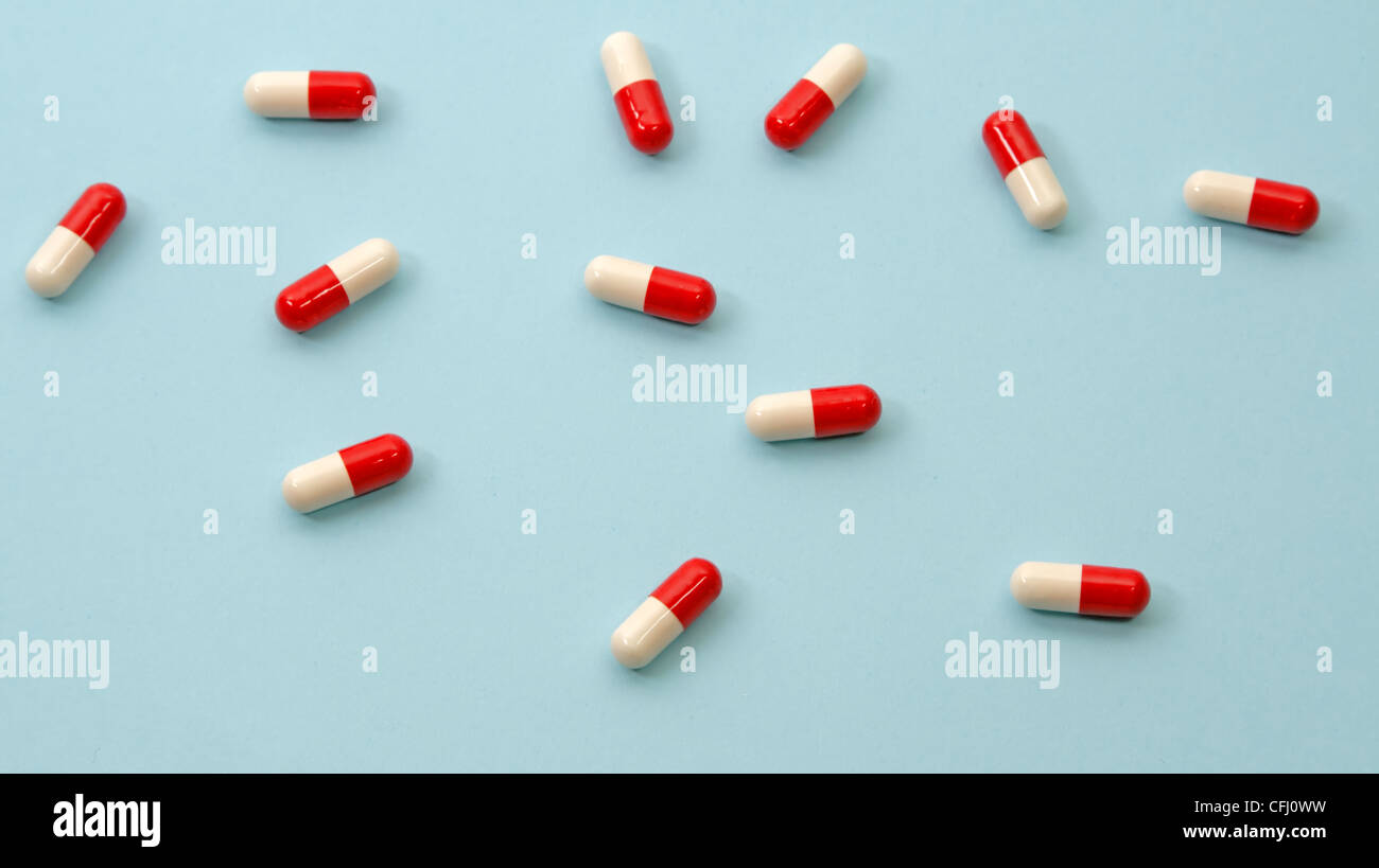 Antibiotics capsules over blue background Stock Photo - Alamy