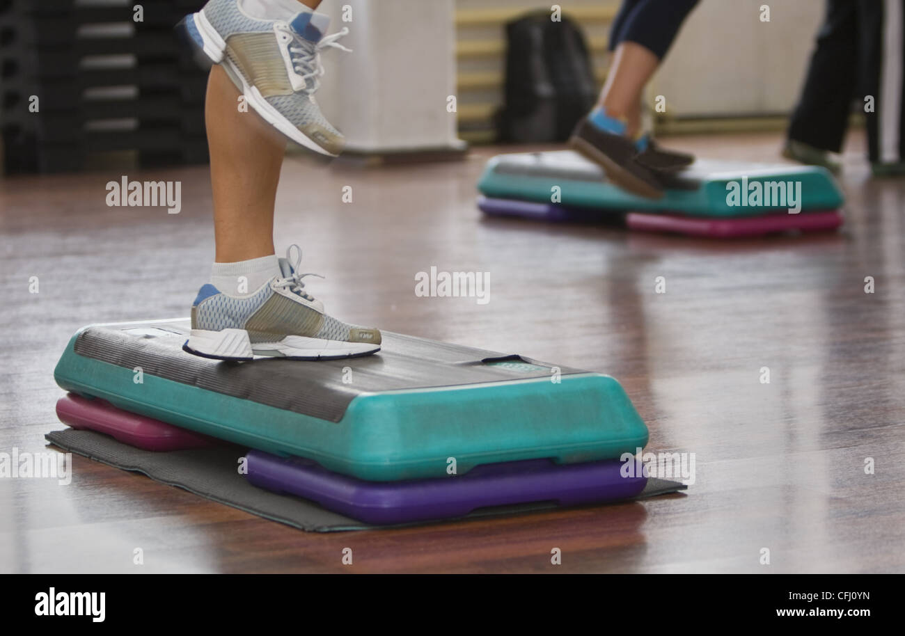 Image of legs doing step aerobics indoors Stock Photo - Alamy