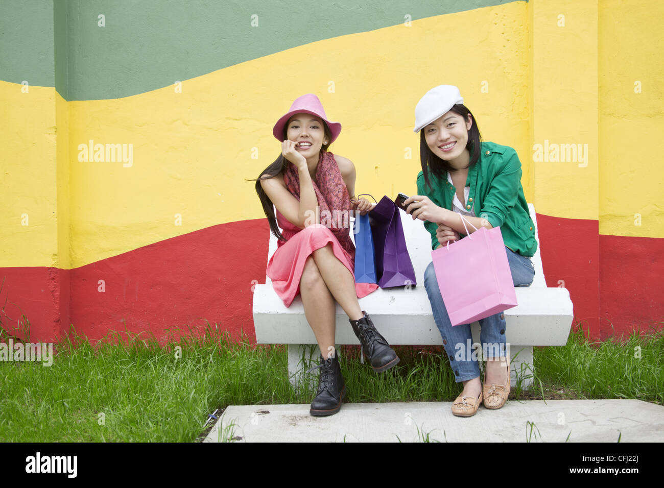 Young women sitting on a bench Stock Photo - Alamy