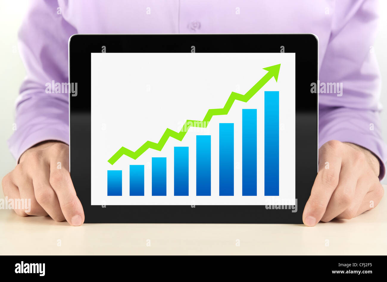 Business man showing tablet pc with success growth graph on screen ...