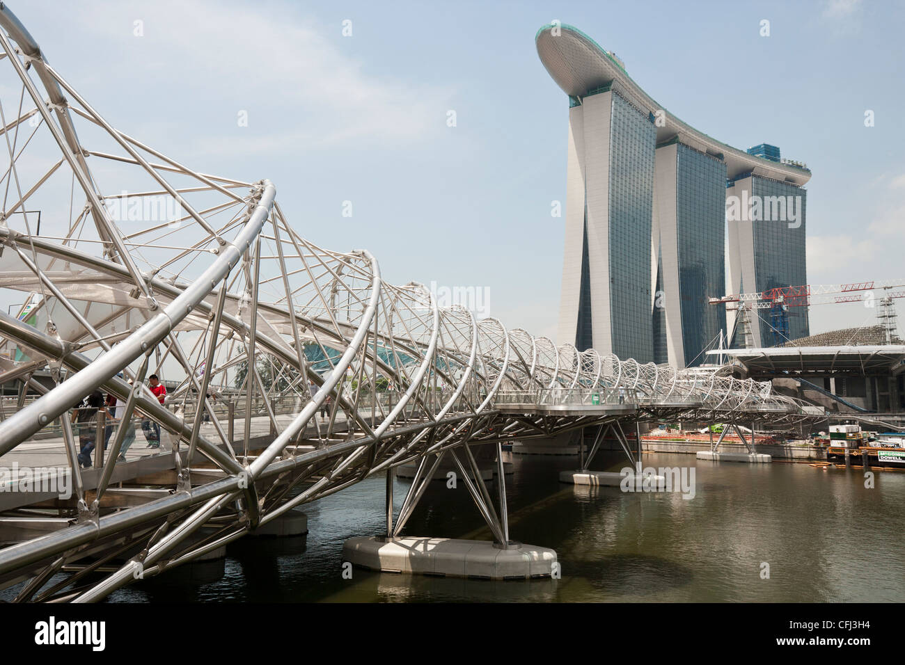 Pedestrians walk along the Helix Bridge, partially completed site of ...