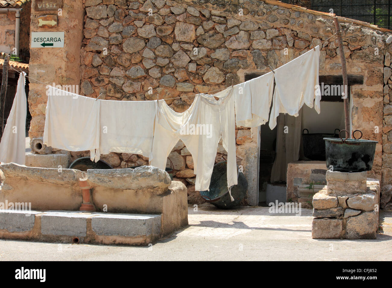 Cream coloured laundry drying on a washing line outside a stone ...