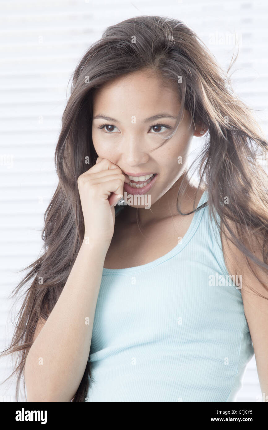 Young woman biting finger Stock Photo - Alamy