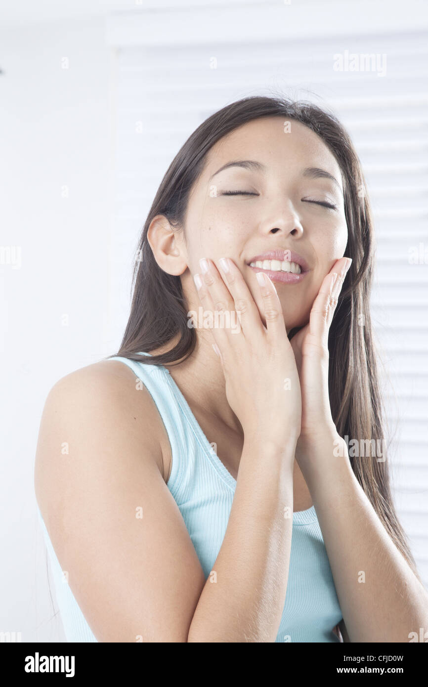 Young woman with hands on cheeks Stock Photo - Alamy