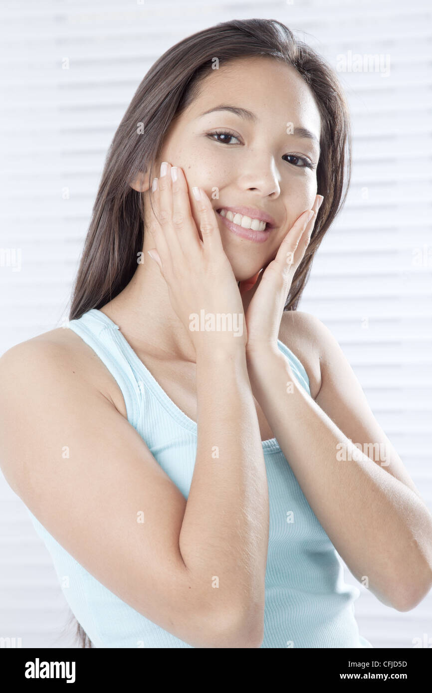Young woman with hands on cheeks Stock Photo - Alamy
