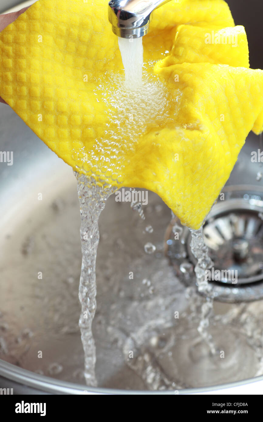yellow cloth and hands under running water Stock Photo - Alamy