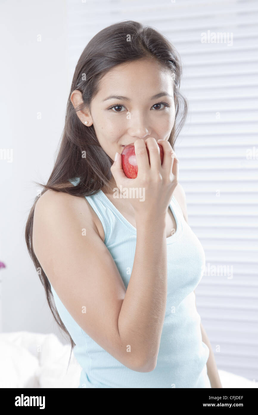 Young woman biting an apple Stock Photo - Alamy