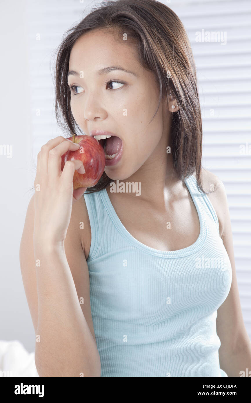 Young woman biting an apple Stock Photo - Alamy