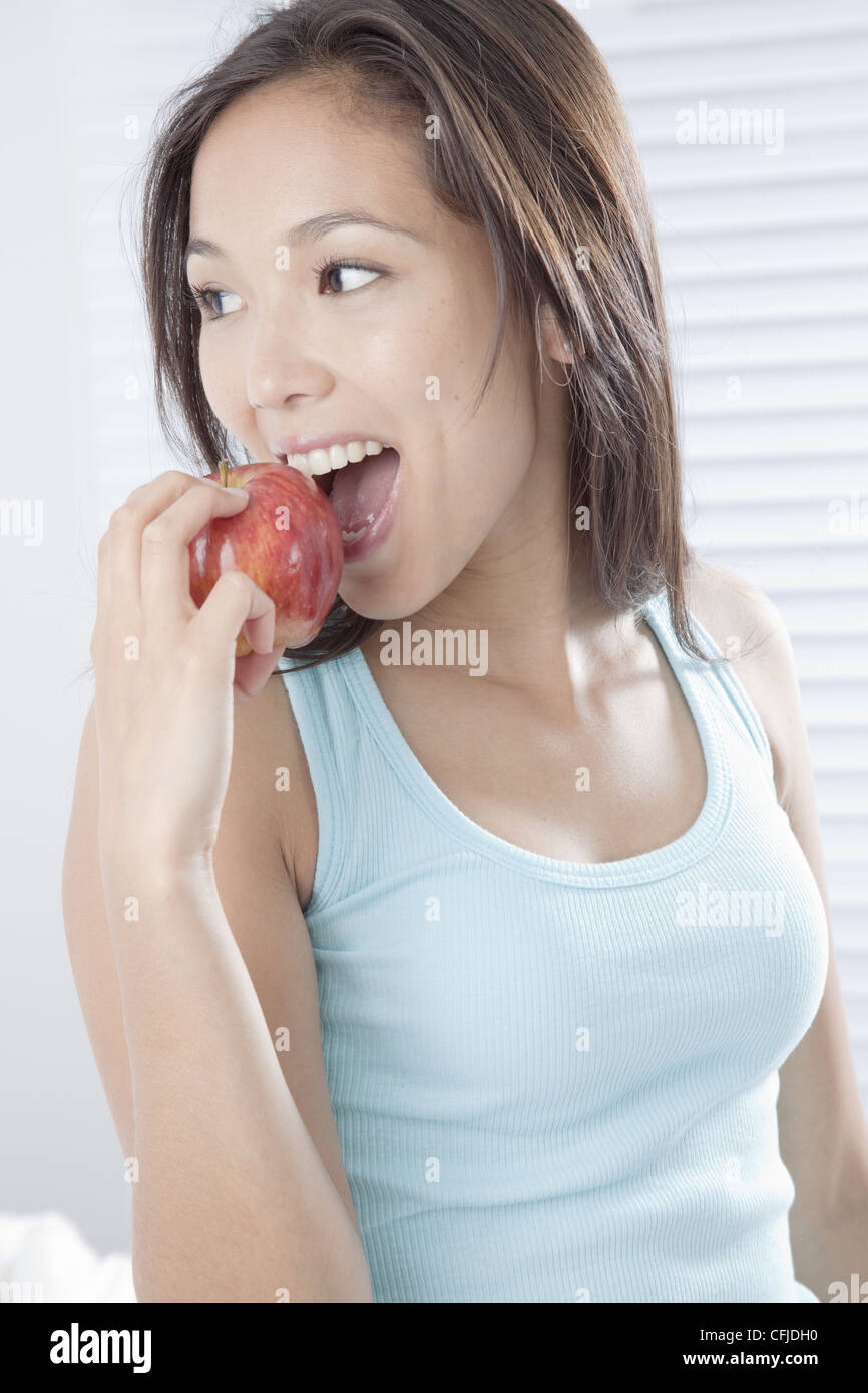 Young woman biting an apple Stock Photo - Alamy