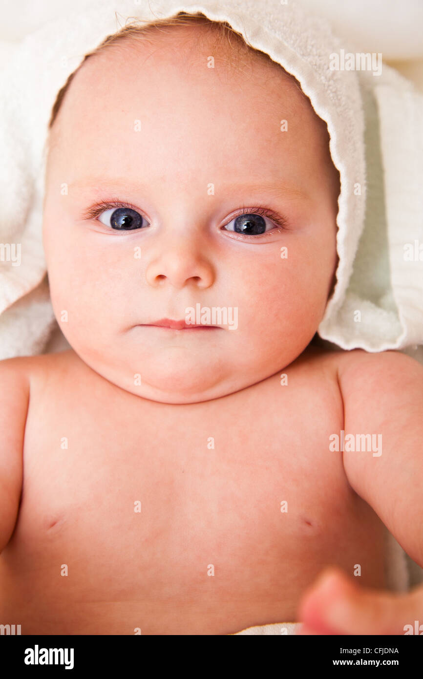 Infant creaming face on white towel Stock Photo - Alamy