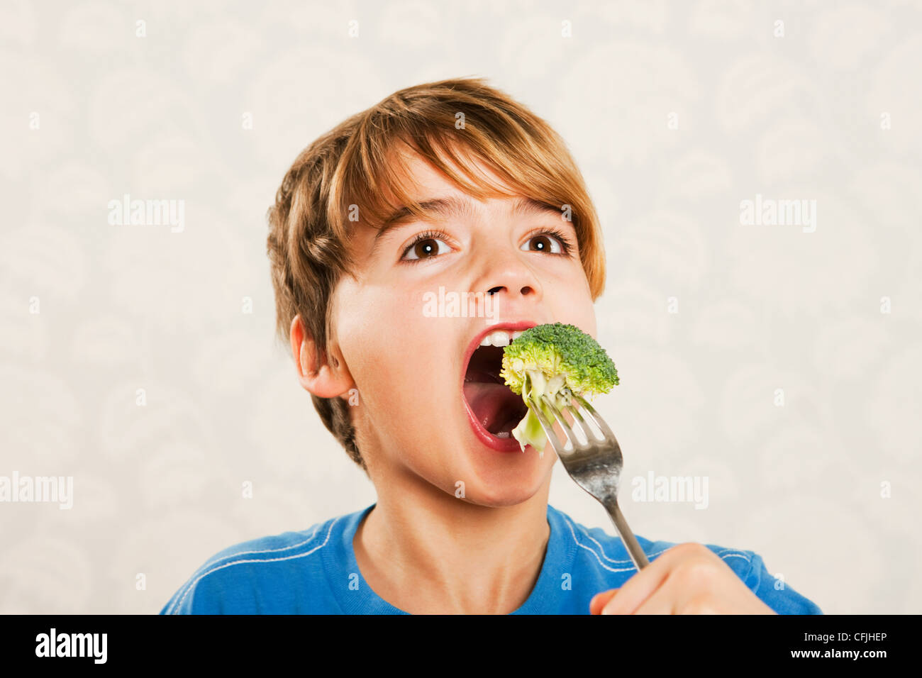 Boy eating broccoli Stock Photo - Alamy