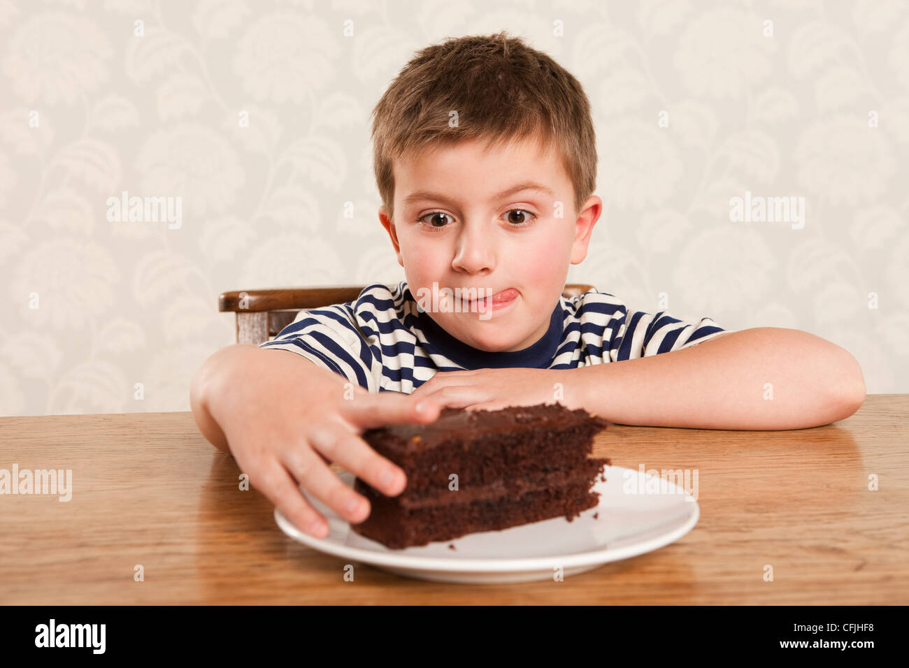 Boy reaching chocolate cake hi-res stock photography and images - Alamy
