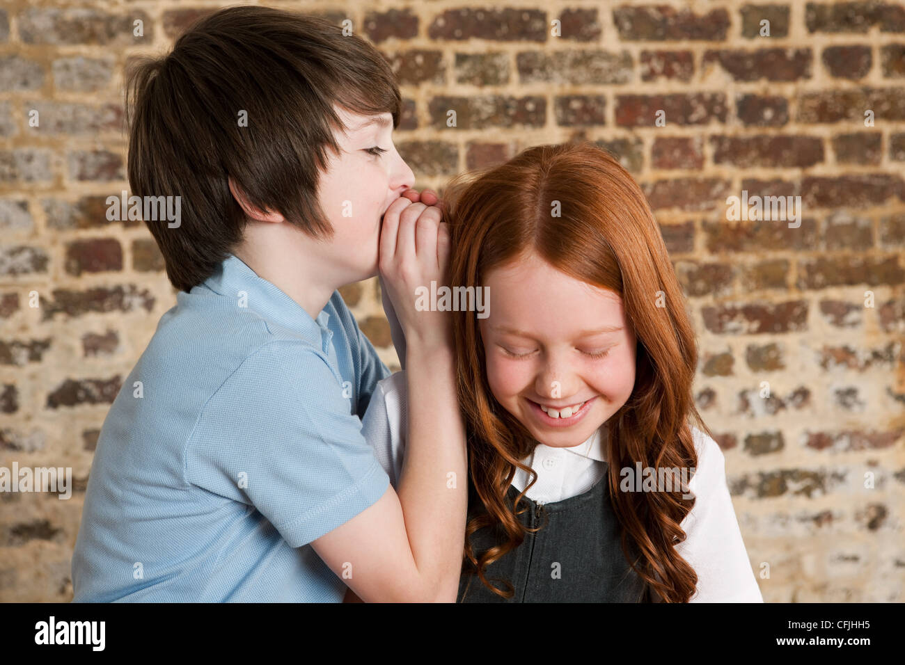 Boy whispering to girl Stock Photo - Alamy