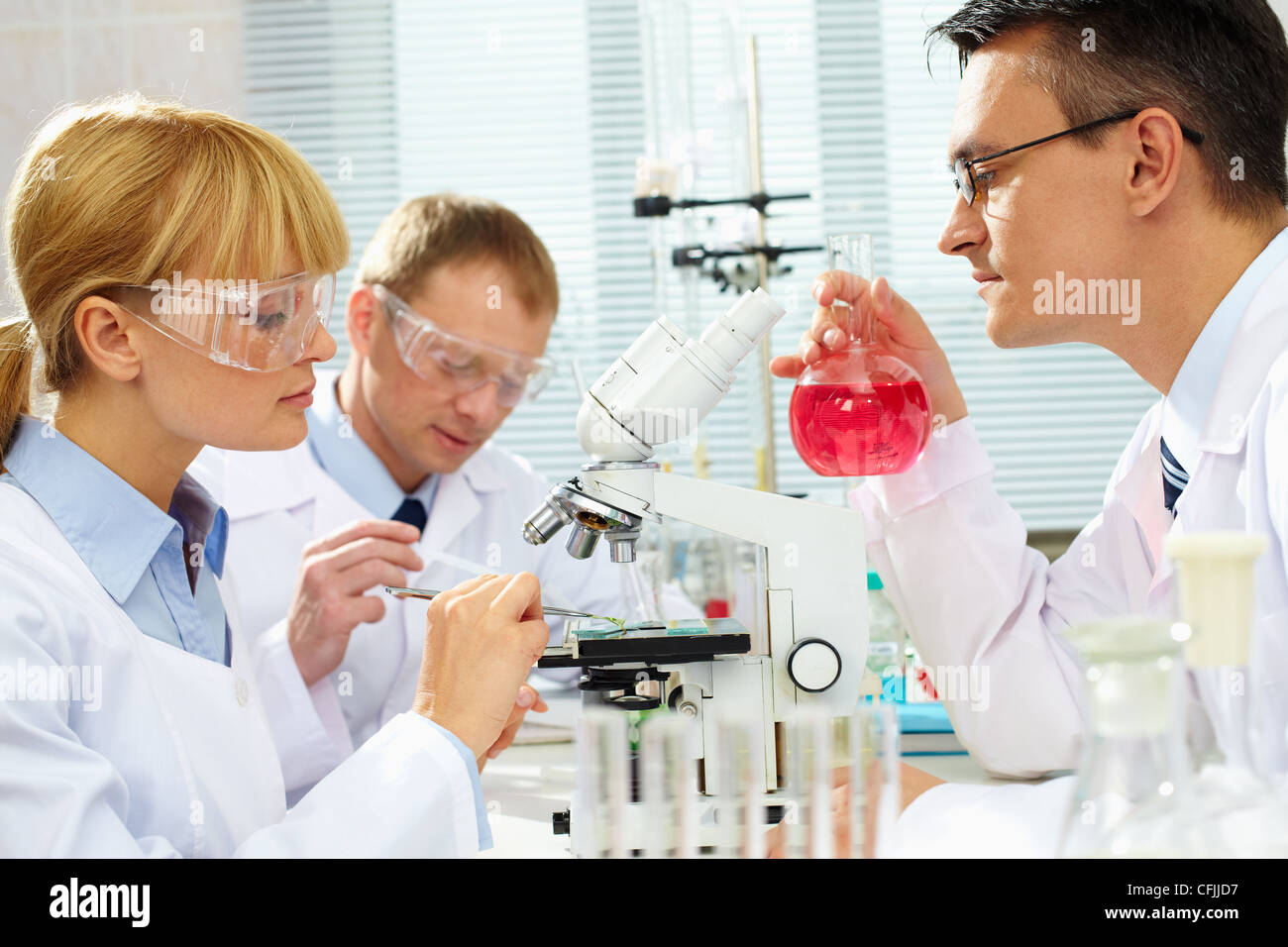 Group of clinicians studying new substance in laboratory Stock Photo ...