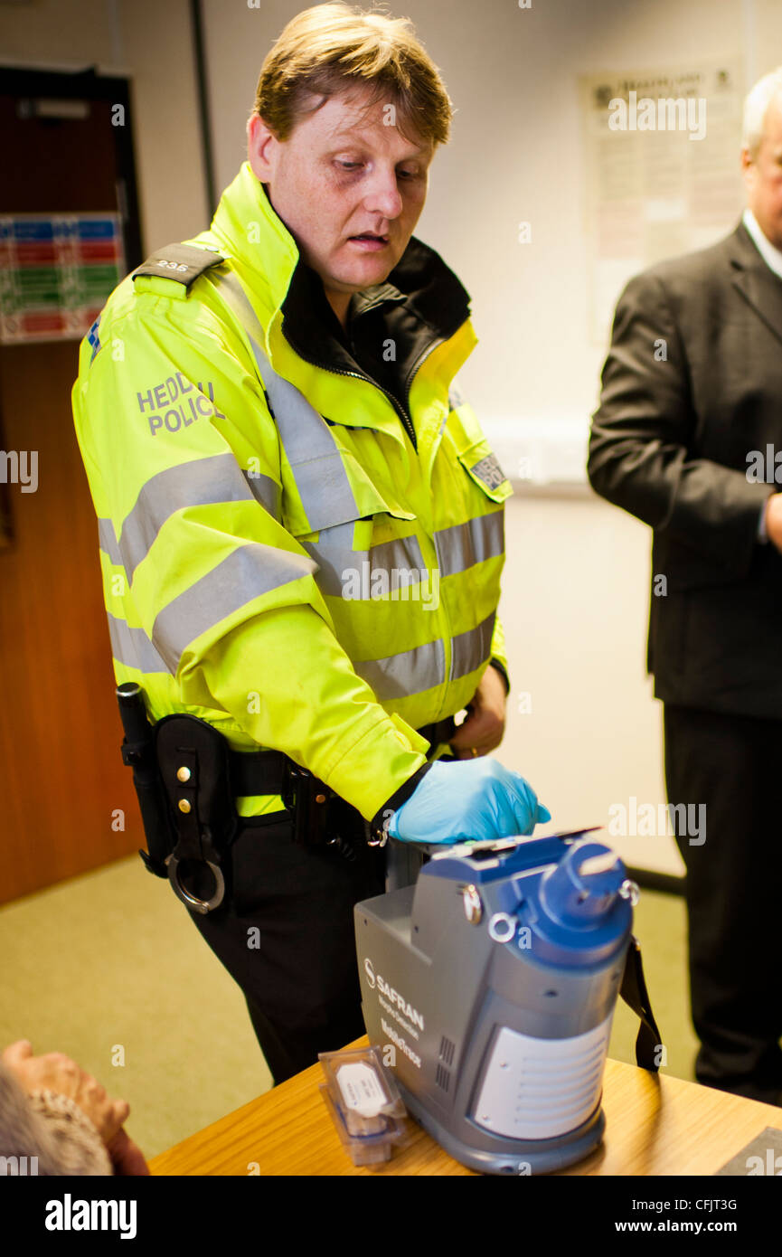 a uniformed police officer calibrating an SAFRAN morpho detection ...
