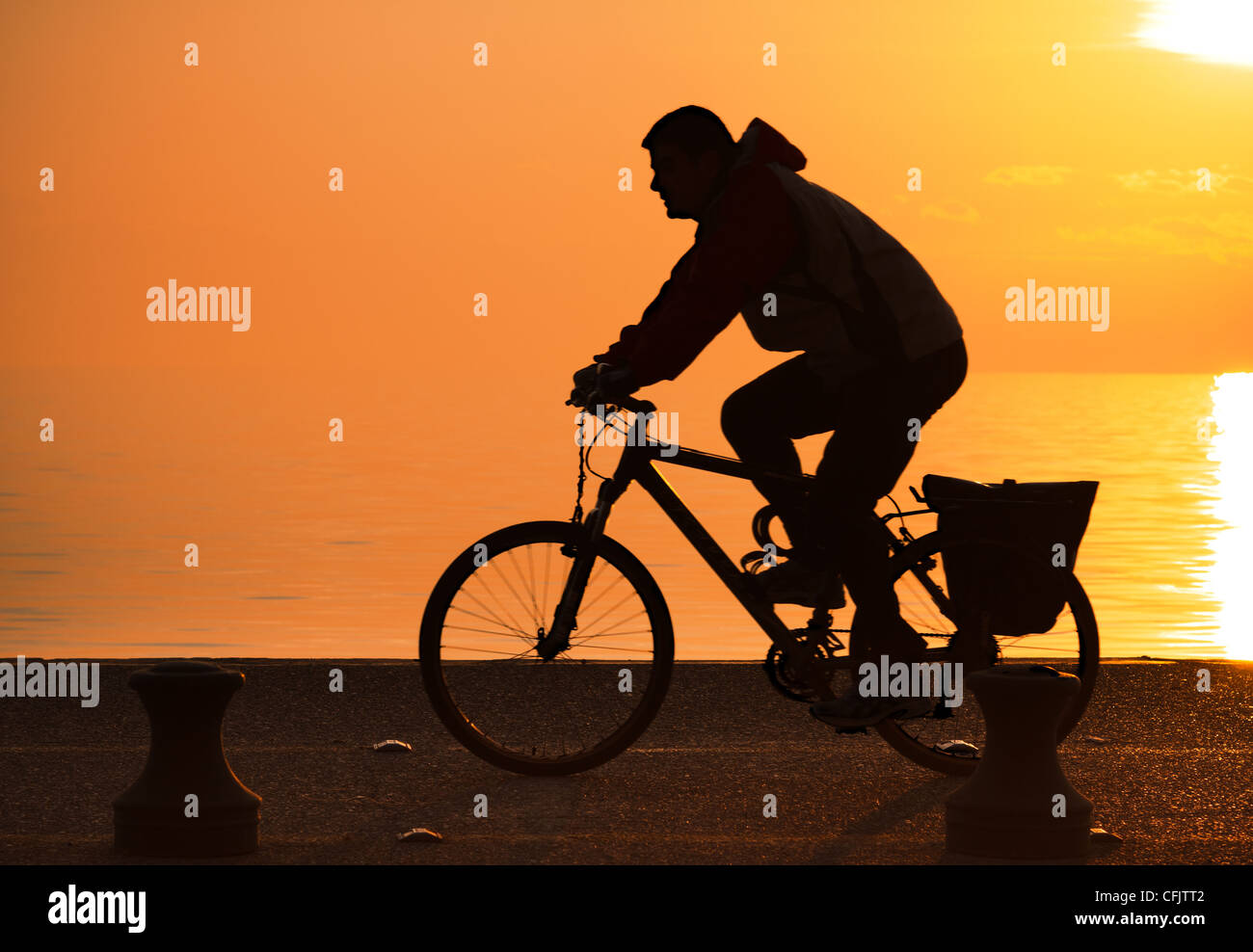 Silhouette of a man riding his bike at sunset, Thessaloniki, Greece ...