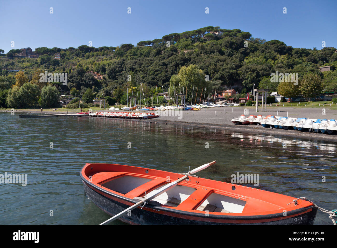 red rowing boat on lake albano looking towards beach and pedalos Stock ...