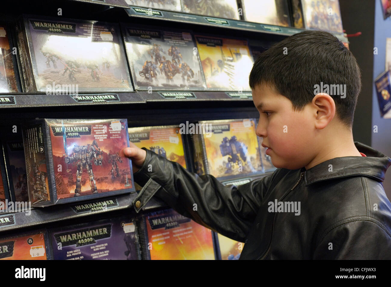 young boy looking at games in games workshop Stock Photo - Alamy