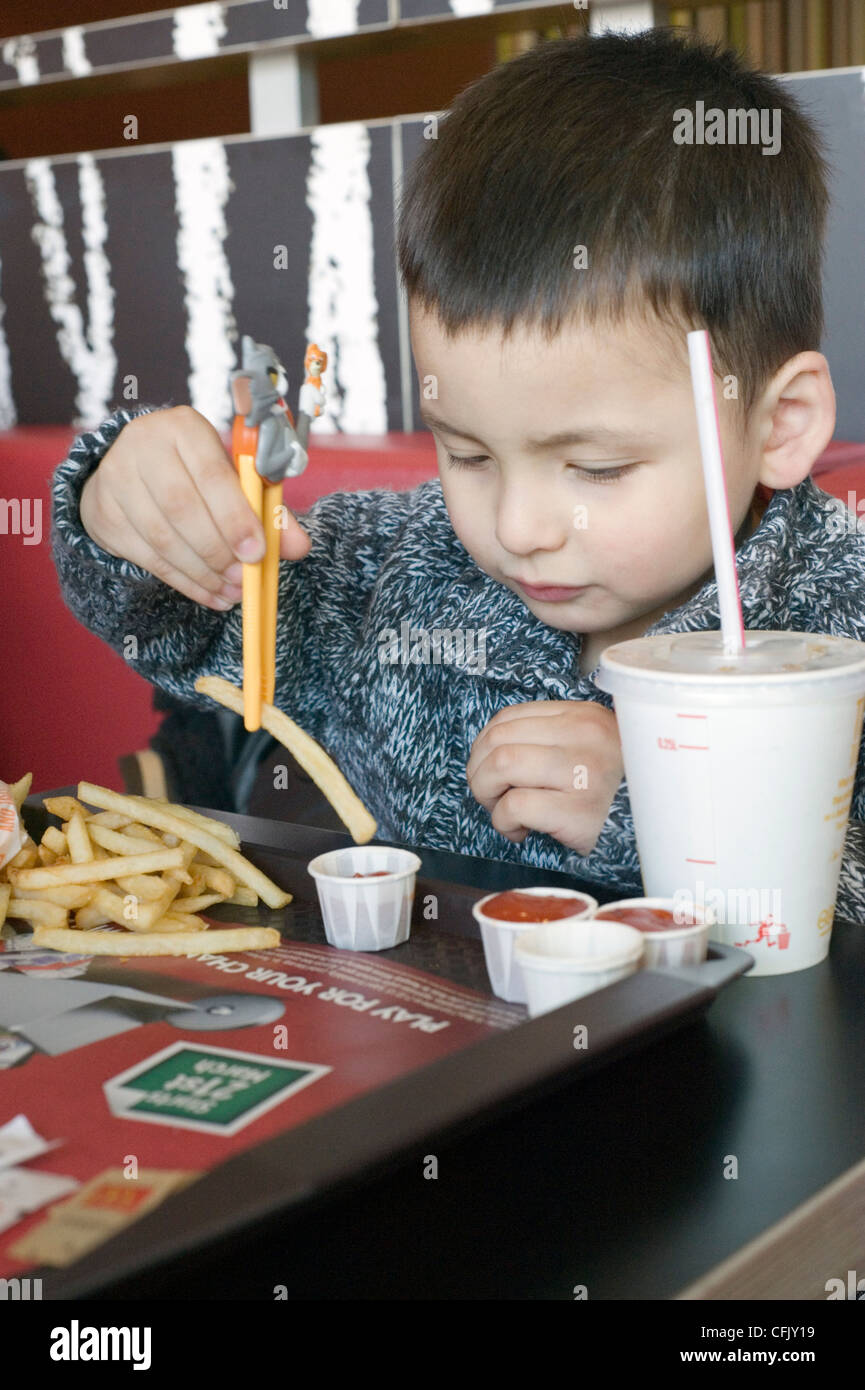 young boy enjoying a meal in a fast food restaurant Stock Photo - Alamy
