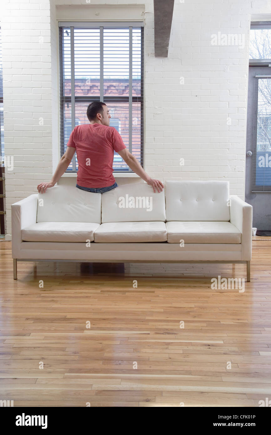 Man Leaning on Back of Couch Stock Photo - Alamy