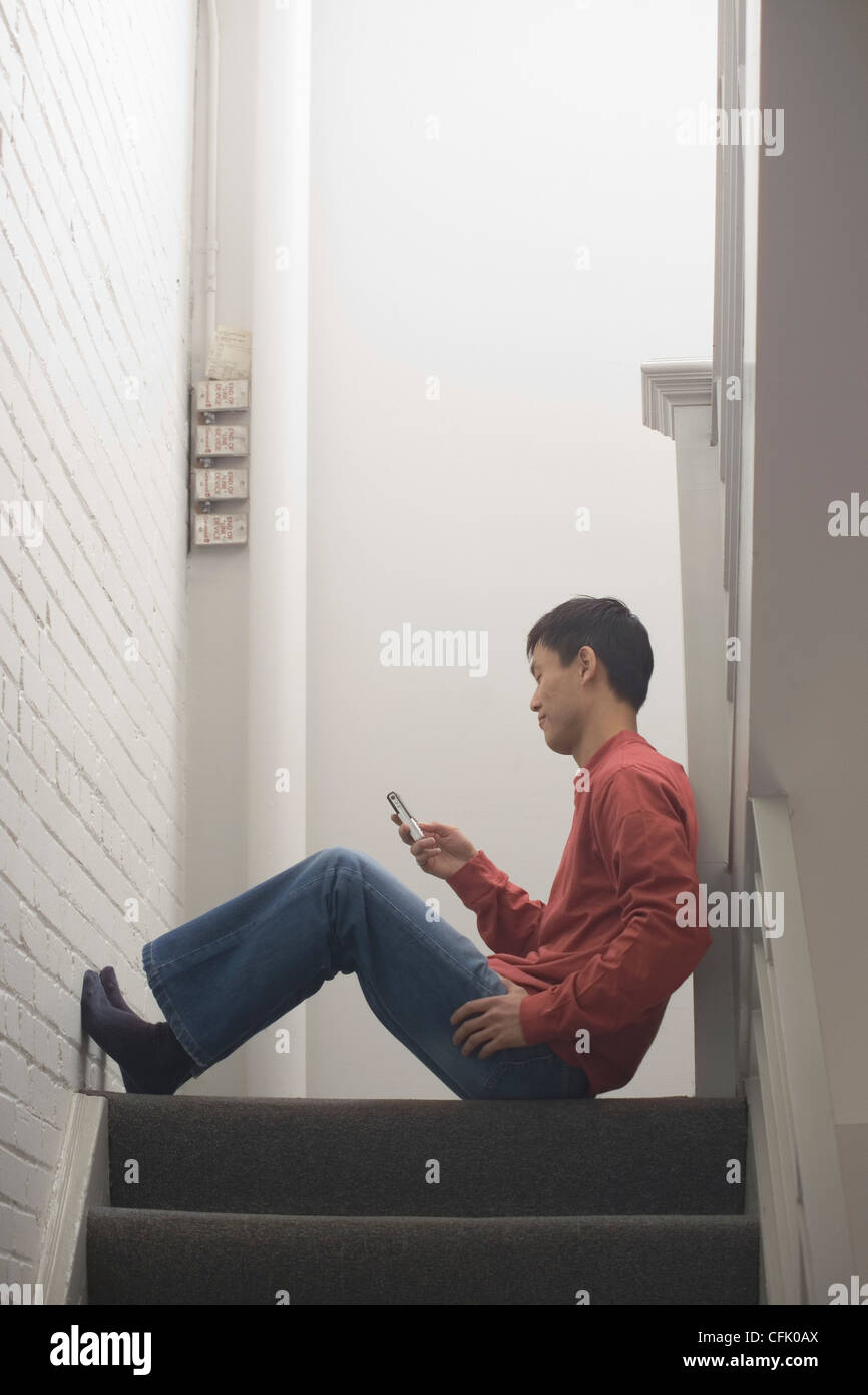 Man Sitting on Stairs Using Cell Phone Stock Photo - Alamy