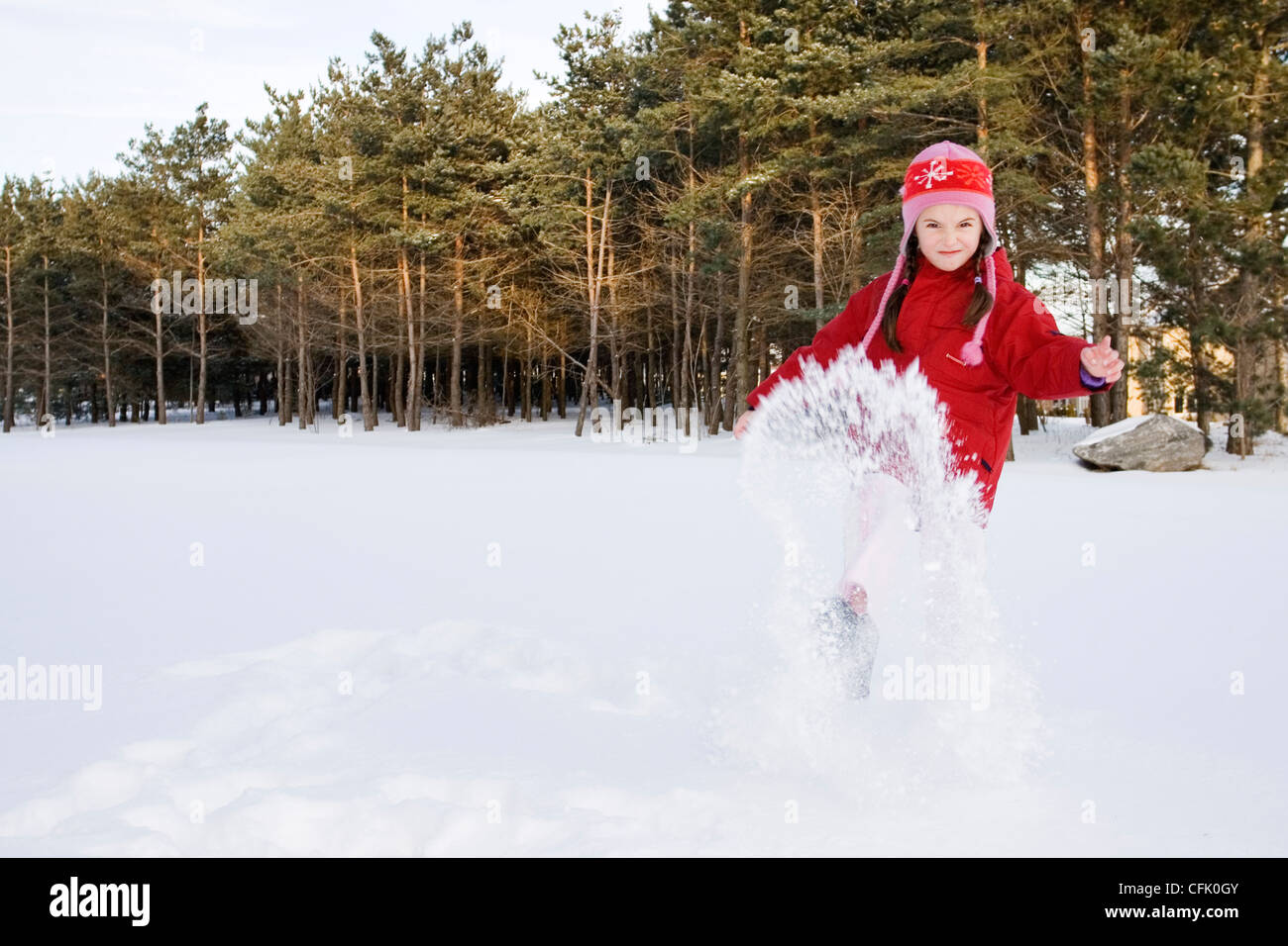Young Girl Kicking Snow in Field Stock Photo - Alamy