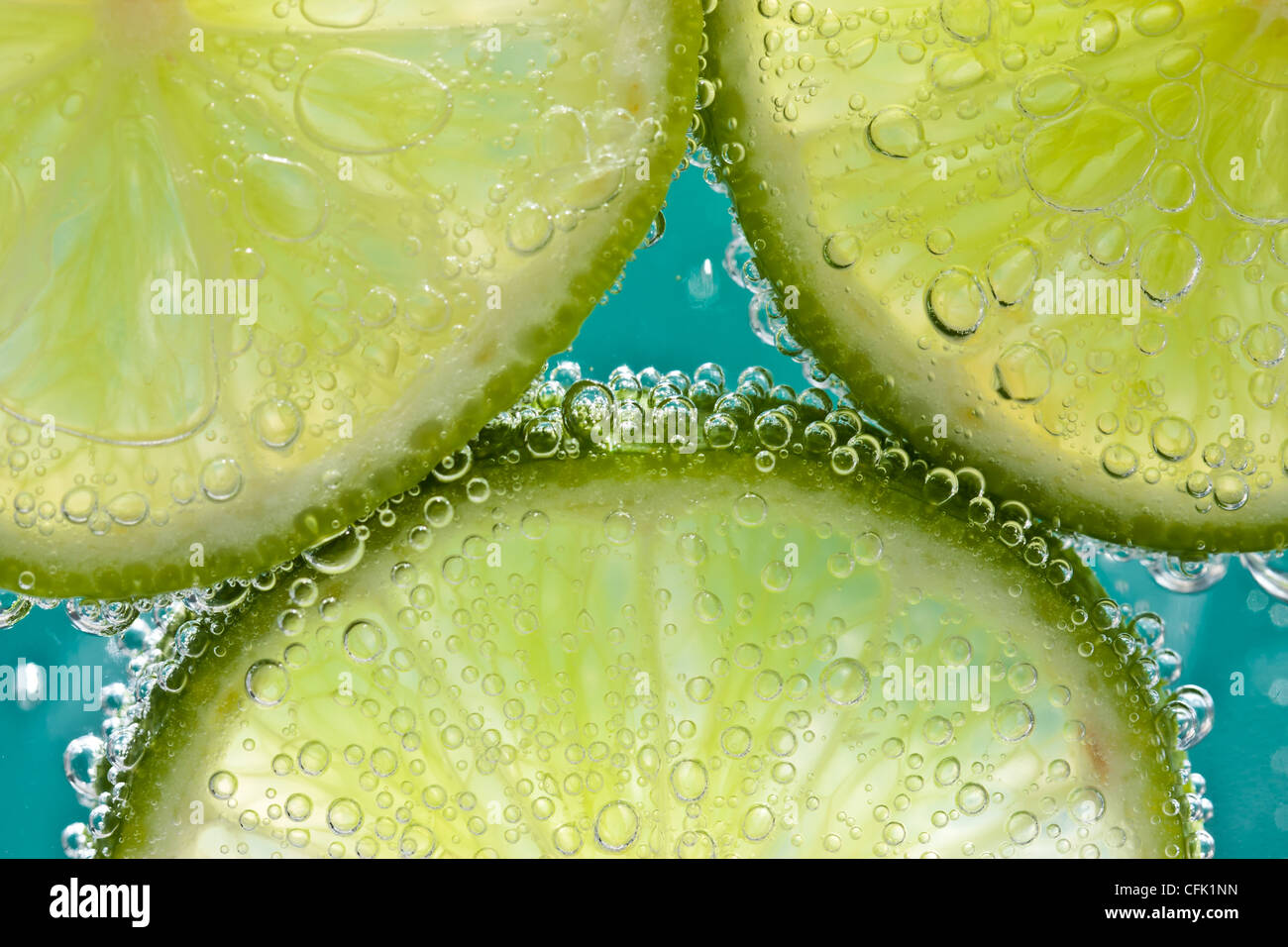 Kiwi fruit cocktail - in fizzy soda water - against an electric blue ...