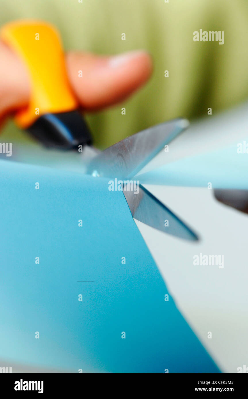 Child Cutting Blue Paper with Scissors Stock Photo - Alamy