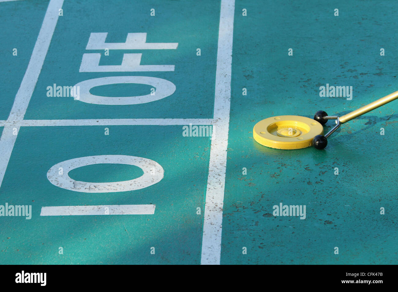 Shuffleboard court. Green game surface with numbers and puck and paddle ...