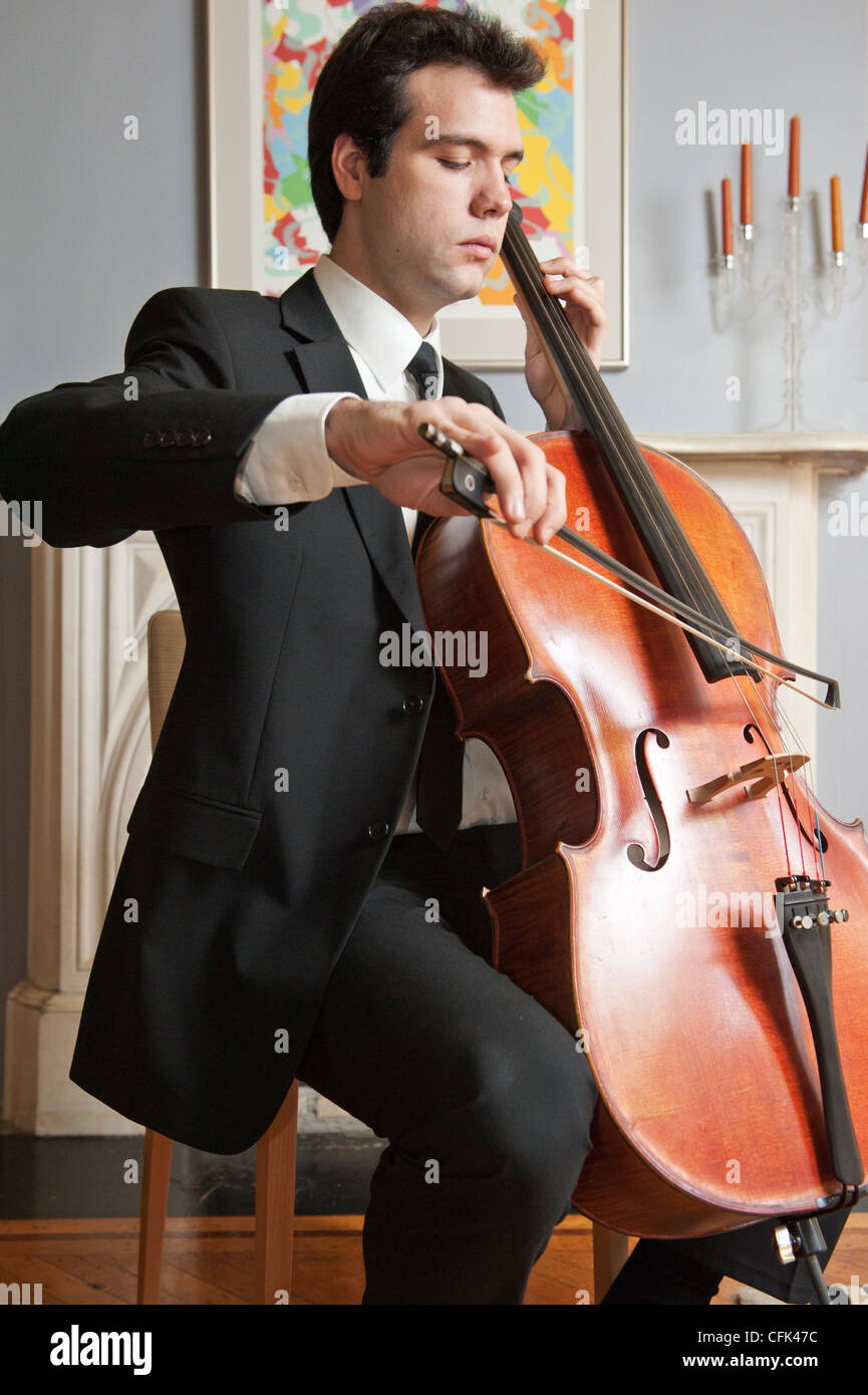 Handsome young man wearing a suit and tie playing the cello Stock Photo ...