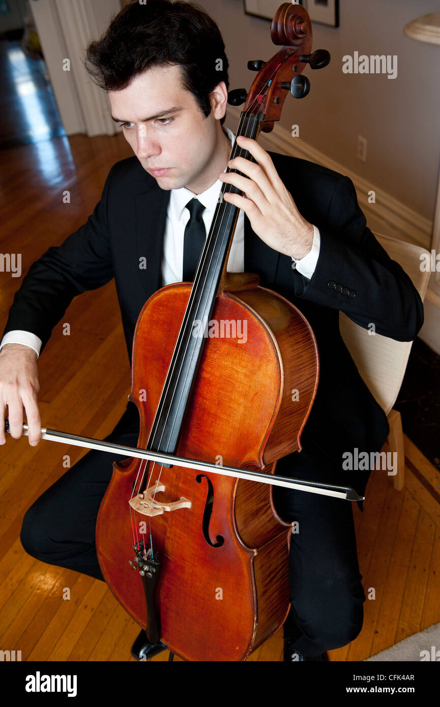 Handsome young man wearing a suit and tie playing the cello Stock Photo ...