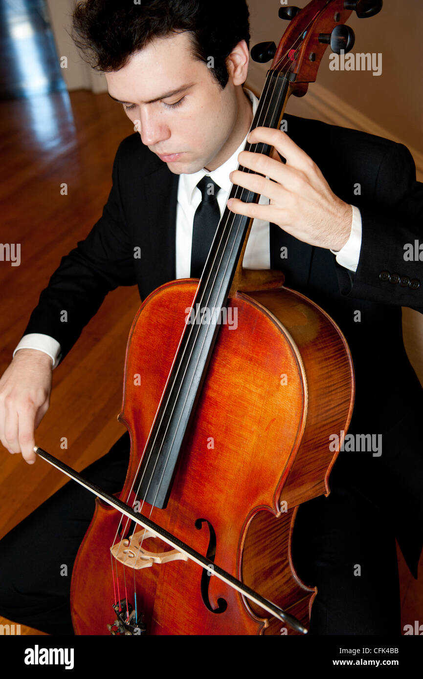 Handsome young man wearing a suit and tie playing the cello Stock Photo ...