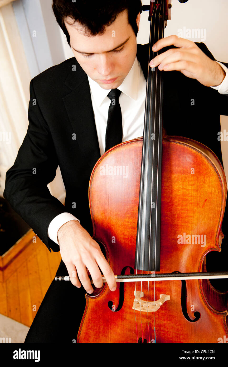 Handsome young man wearing a suit and tie playing the cello Stock Photo ...