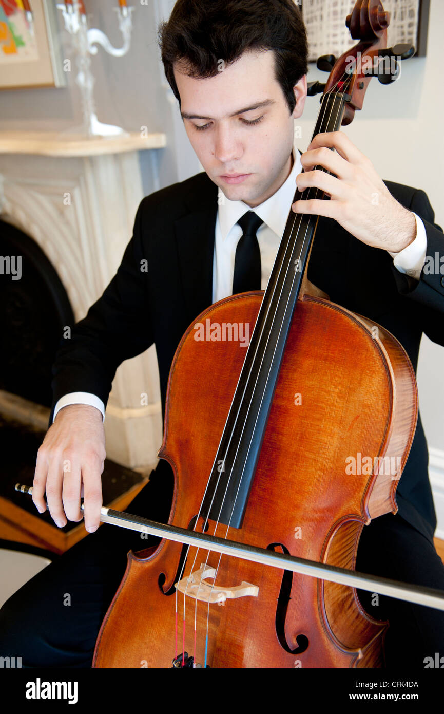 Handsome young man wearing a suit and tie playing the cello Stock Photo ...