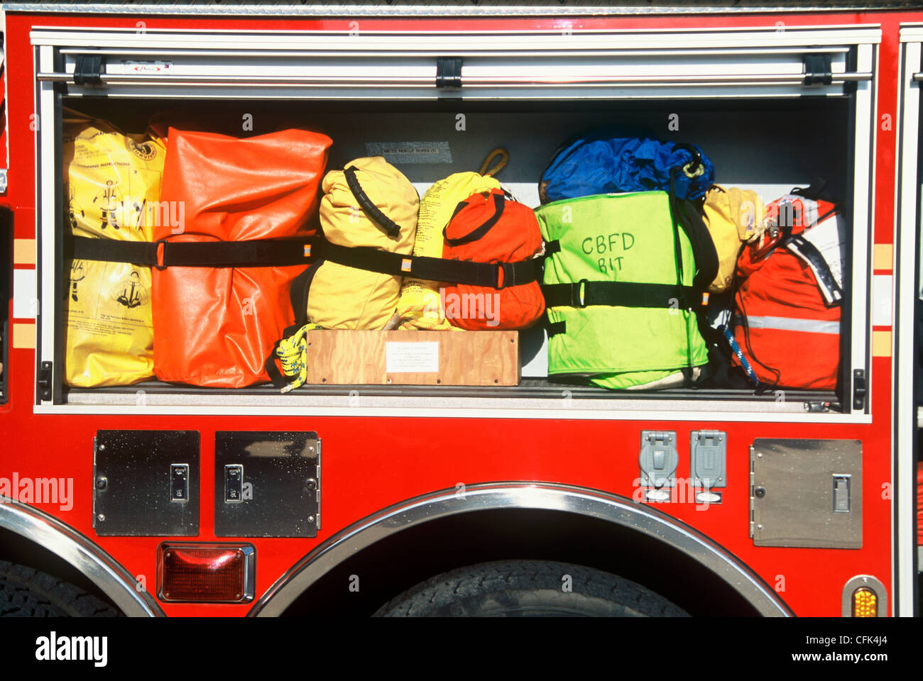 A fire engine cabinet is open reveling the colorful equipment inside ...