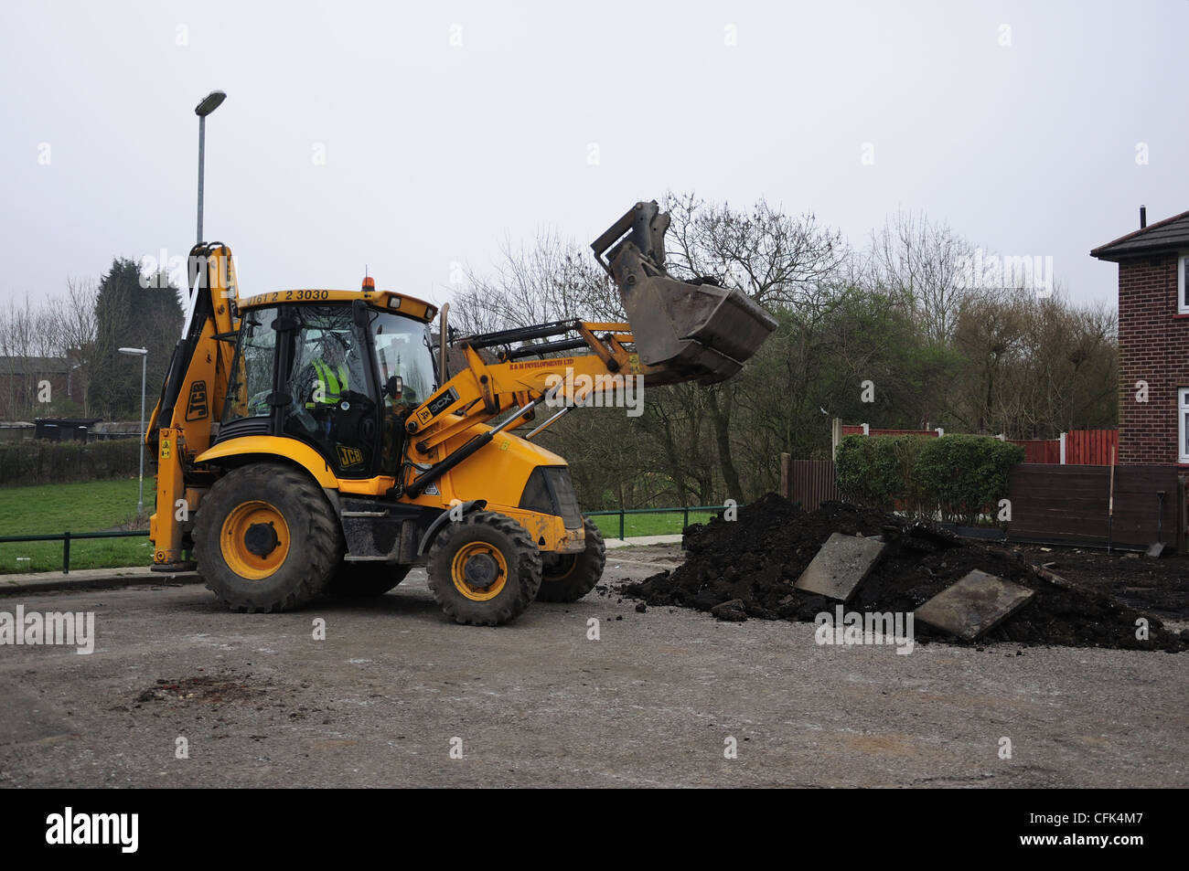 Yellow JCB with full bucket load about to unload into waiting lorry out ...