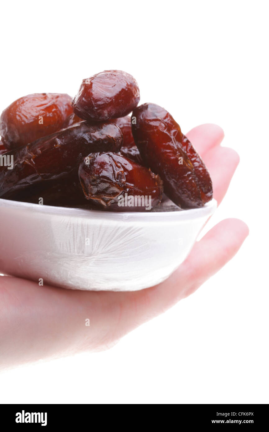 Dried date fruits in hand isolated on white background Stock Photo - Alamy