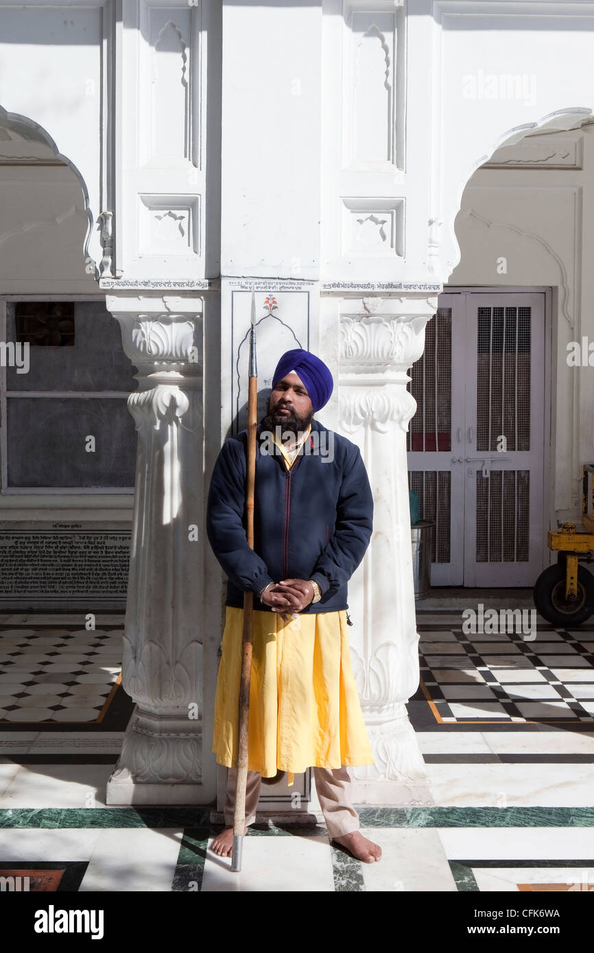 A temple guard stands holding a spear at his post at the Haramandir ...