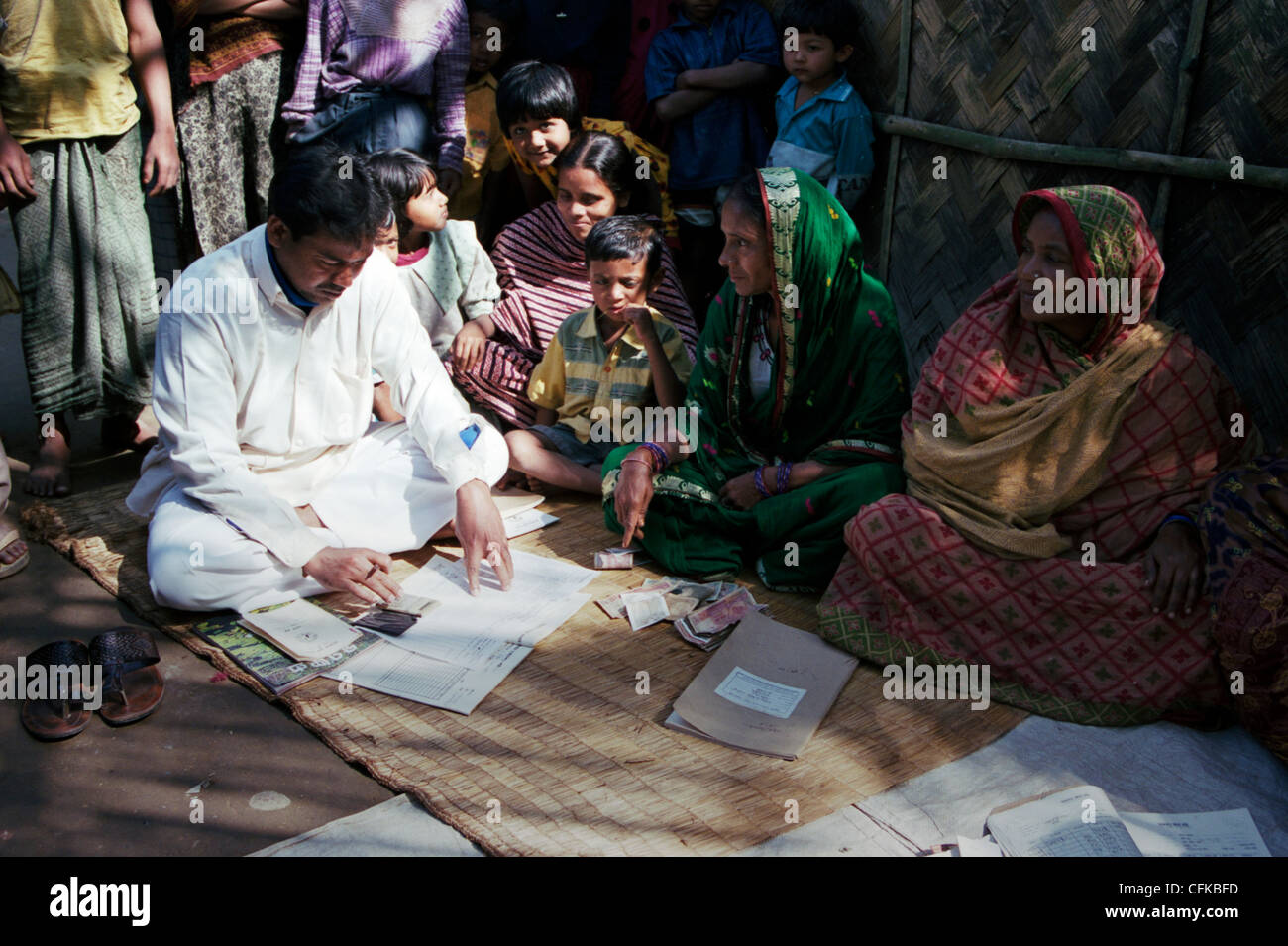 A man from the Grameen Bank is collecting money from women Stock Photo ...