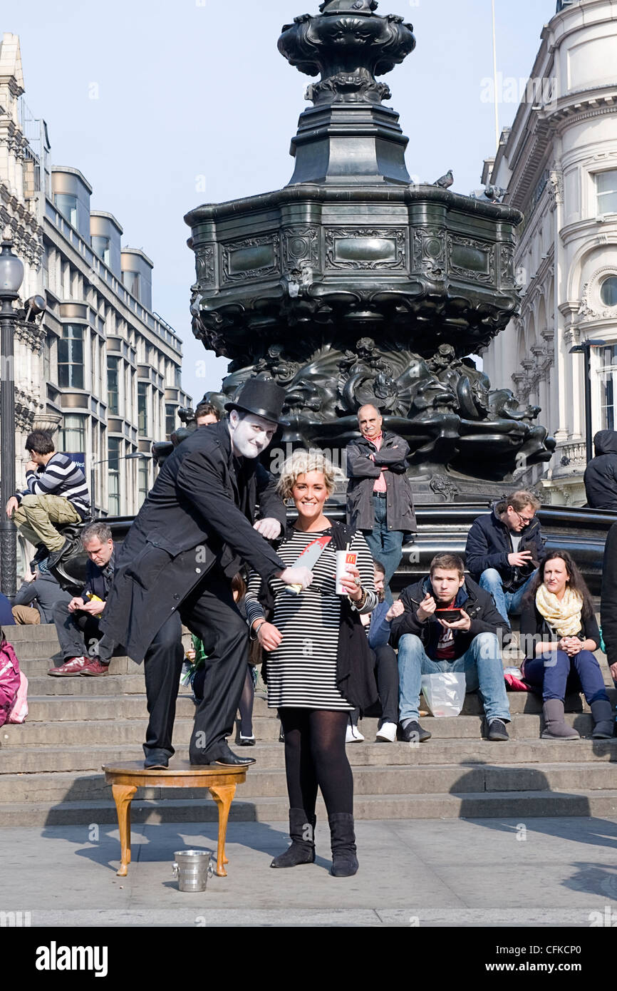 Piccadilly Circus London statue of Eros mime artist poses with pretty ...