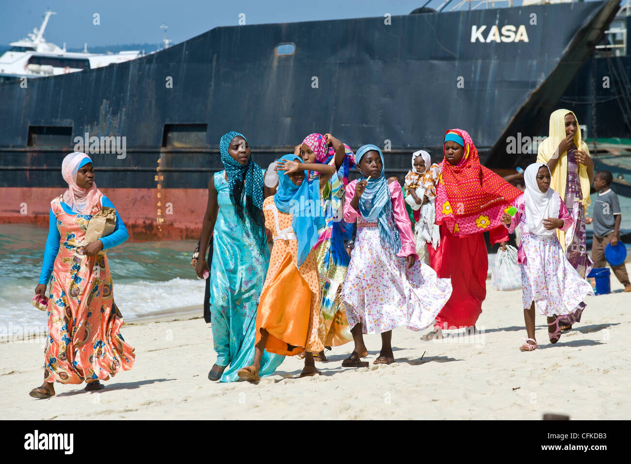 Swahili Women In Traditional Dresses Walking On The Beach In Stone