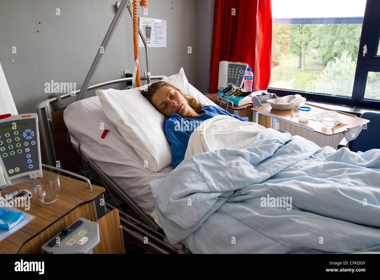 Young woman recovering from operation in hospital bed Stock Photo ...