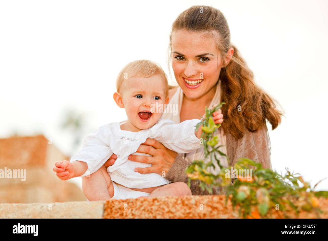 Portrait of happy mother and laughing baby playing with plants Stock ...